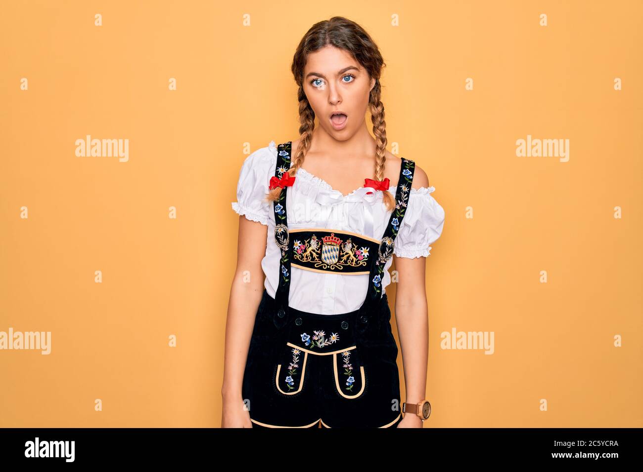 Young beautiful blonde german woman with blue eyes wearing traditional ...