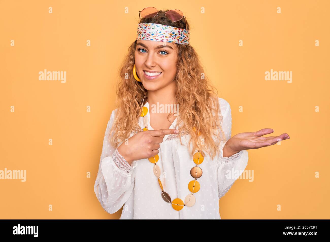 Young beautiful blonde hippie woman with blue eyes wearing sunglasses ...