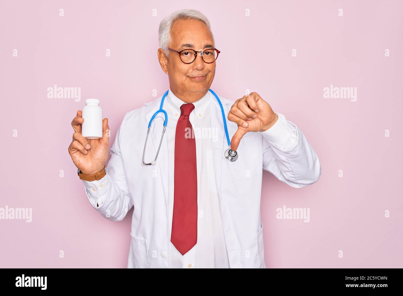 Middle age senior grey-haired doctor man holding prescription pills ...