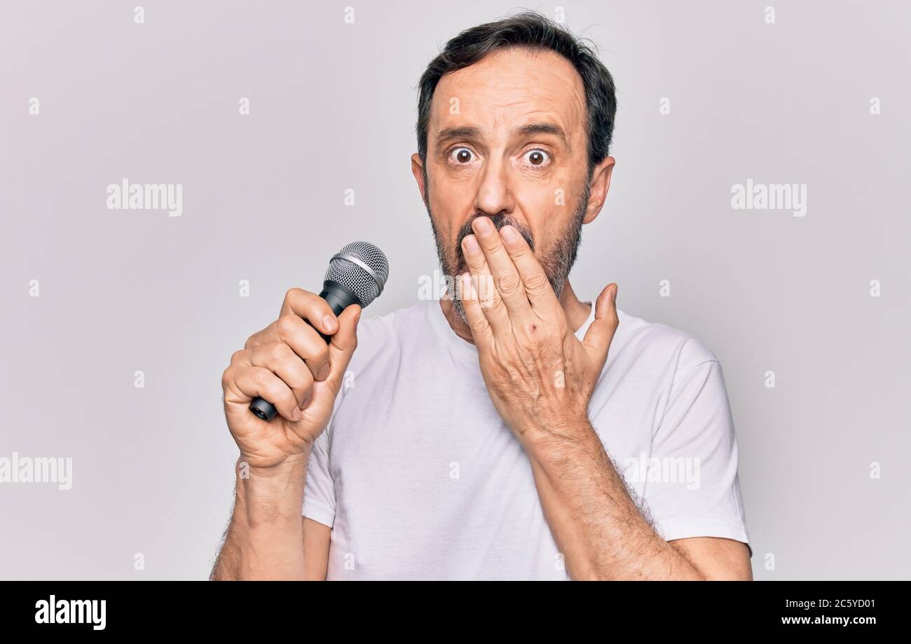 Middle age handsome singer man singing using microphone over isolated ...