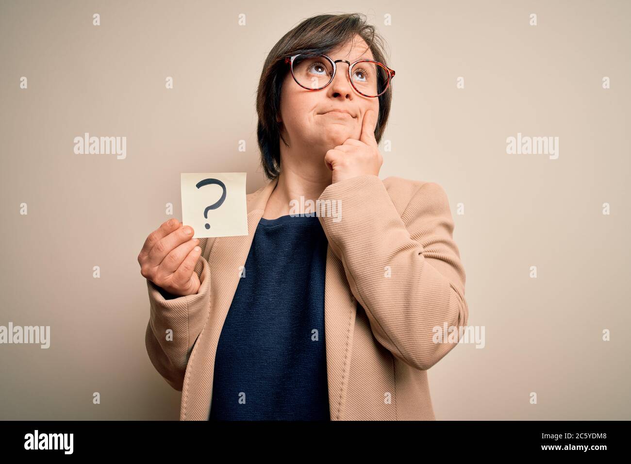Young down syndrome business woman holding question mark paper as doubt ...