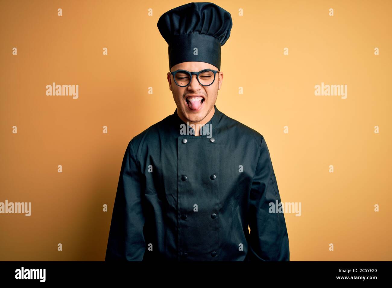 Young brazilian chef man wearing cooker uniform and hat over isolated ...