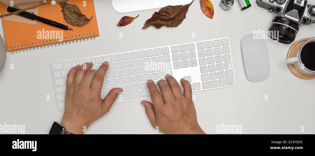 Top view of hands typing on wireless computer keyboard on white office ...