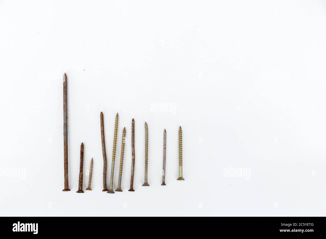 rusty nails are laid out in order from large to small on a white ...
