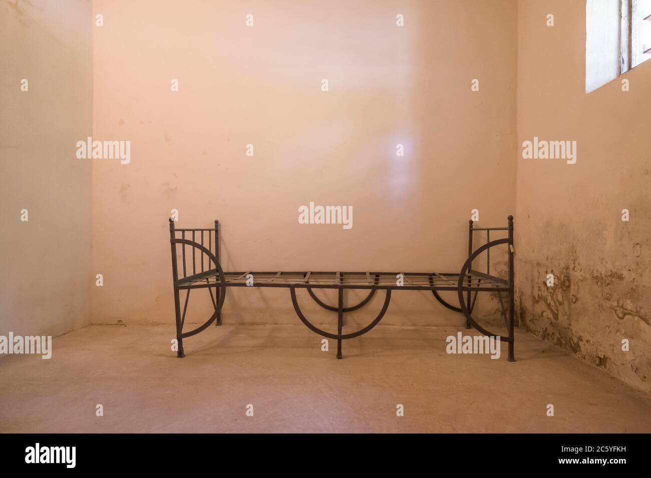 An empty metal bed in the former prison building used by the German ...