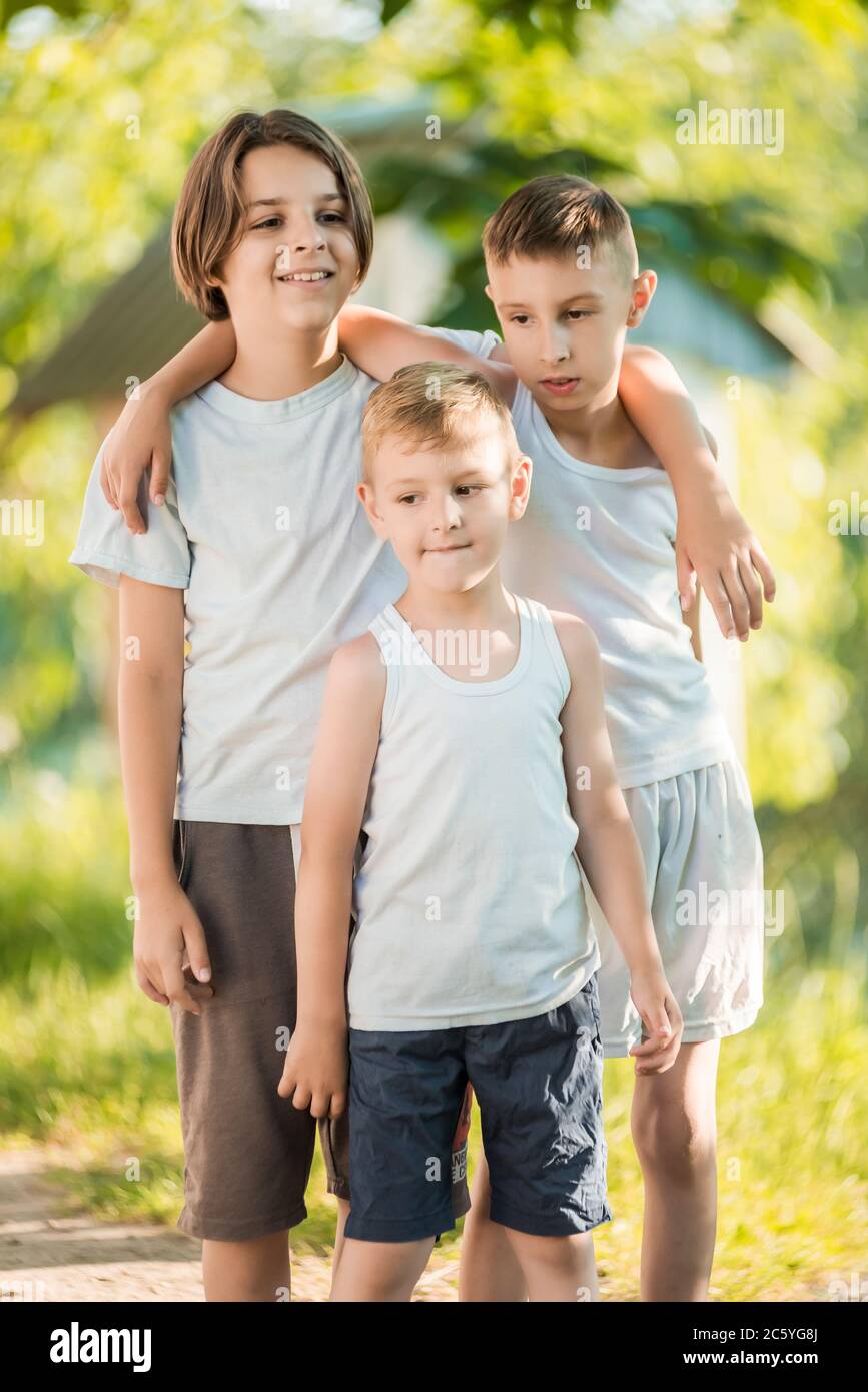 three happy boys posing outside Stock Photo - Alamy