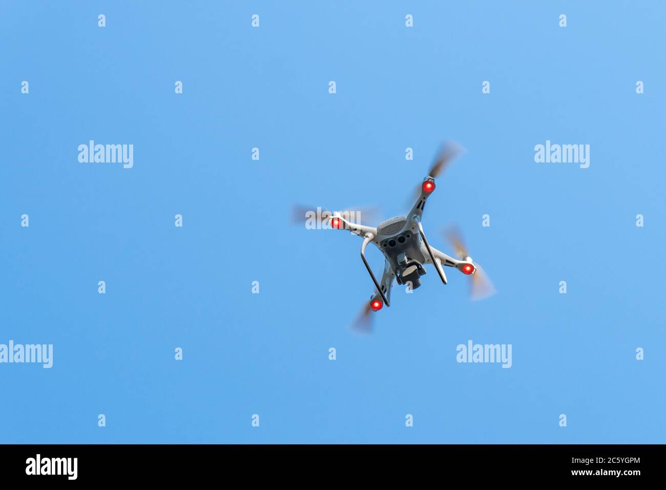 Flying drone with blue sky background Stock Photo - Alamy