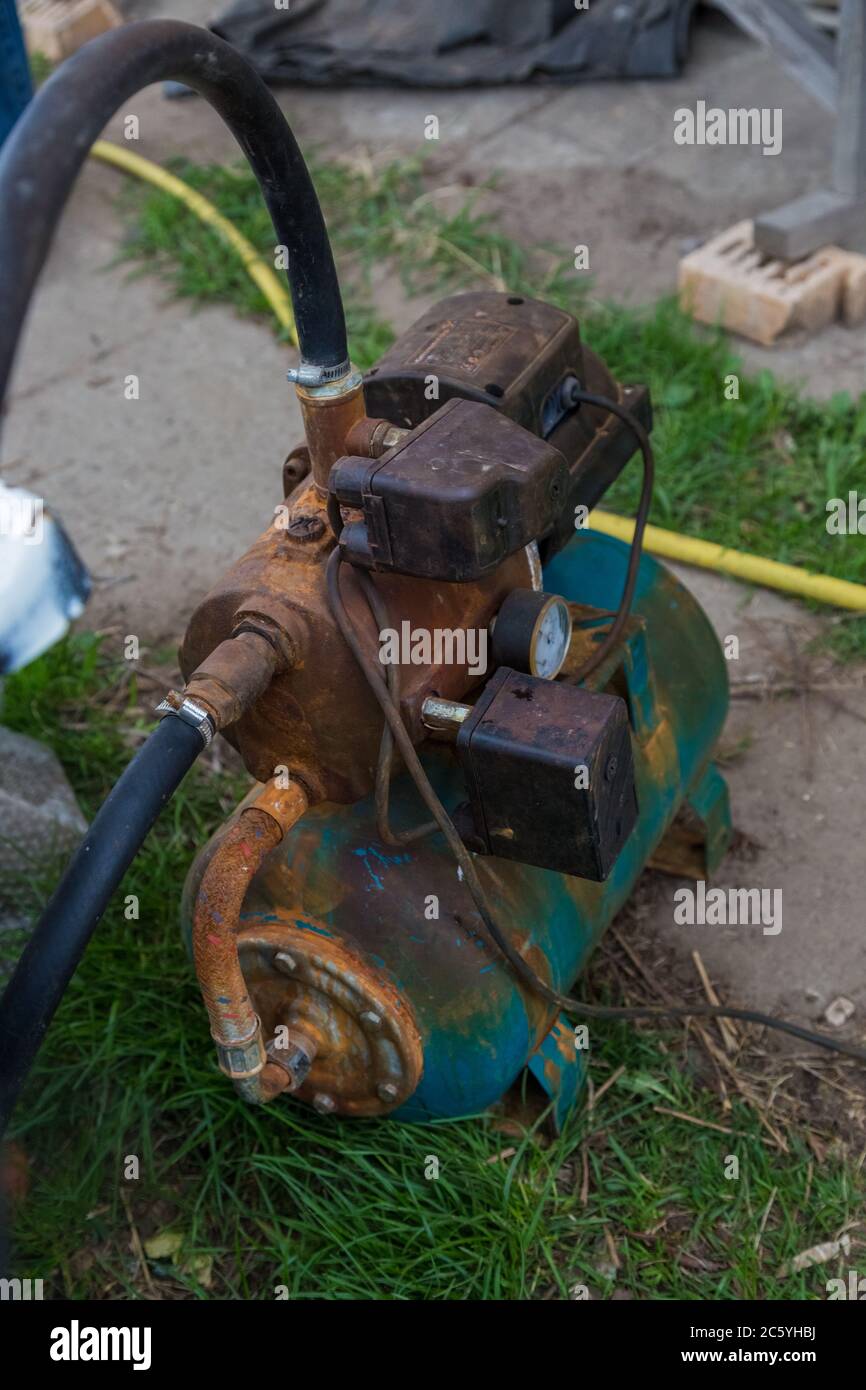 Old rusty pump stands in the garden Stock Photo - Alamy