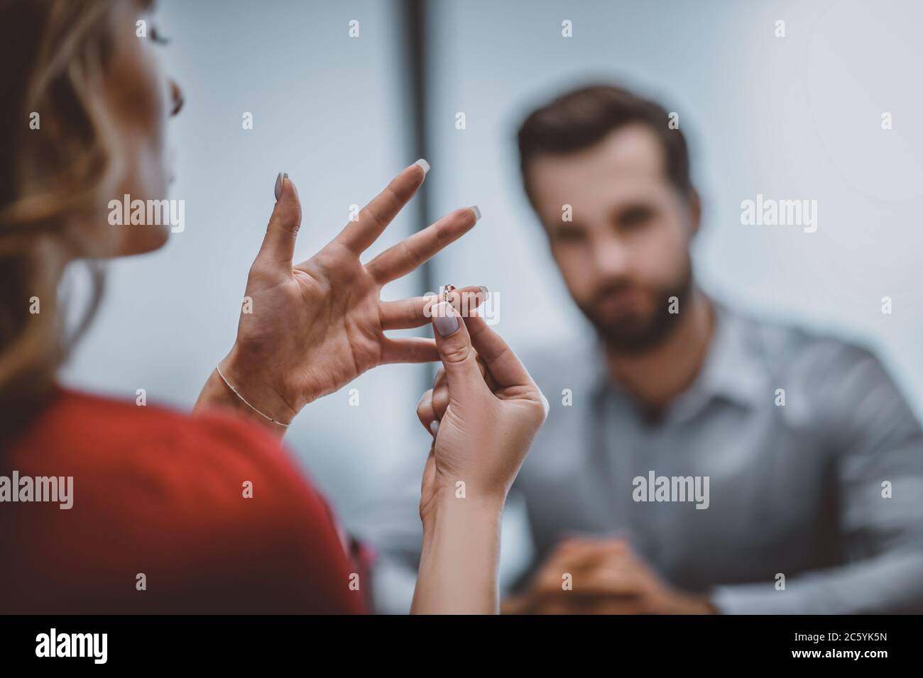 Woman taking off a wedding ring in front of her husband Stock Photo - Alamy
