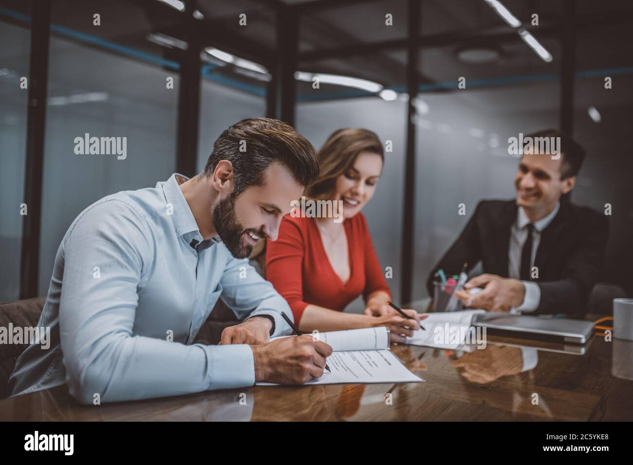 Smiling man and his wife signing a contract Stock Photo - Alamy