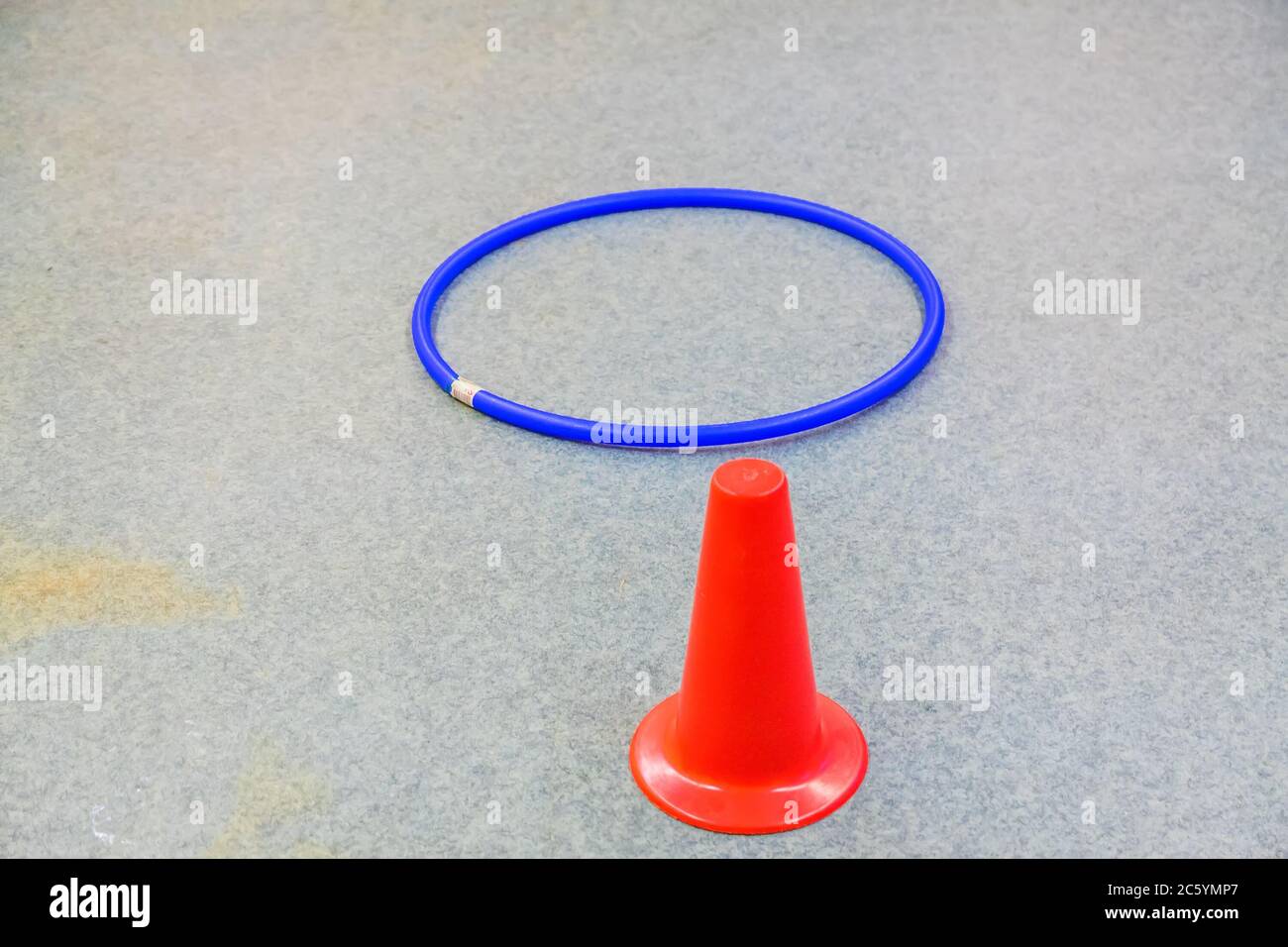plastic blue hoop and red cone on gym floor closeup Stock Photo - Alamy