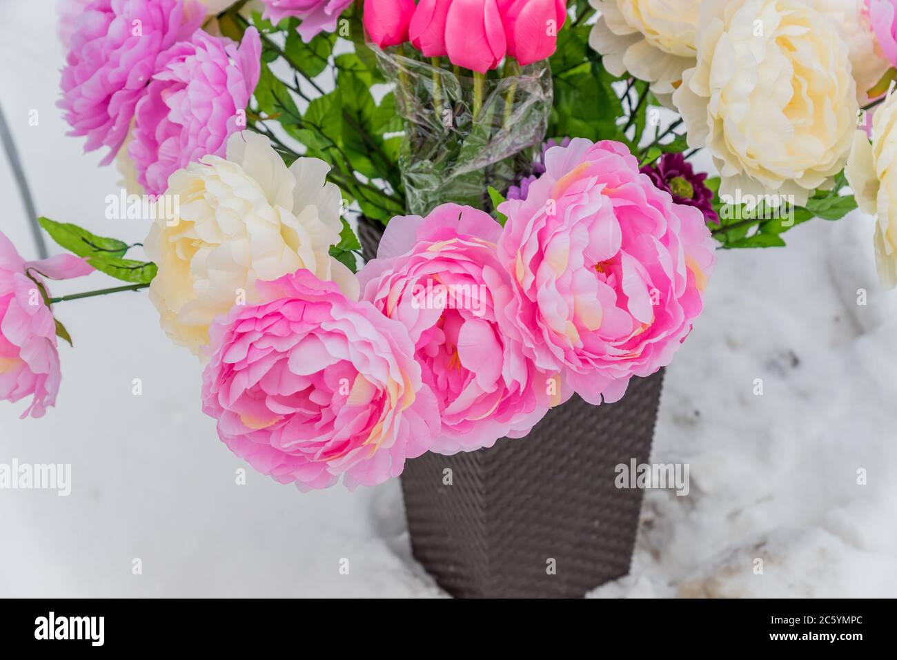 bunch of artificial pink and white peonies in plastic rattan basket on ...