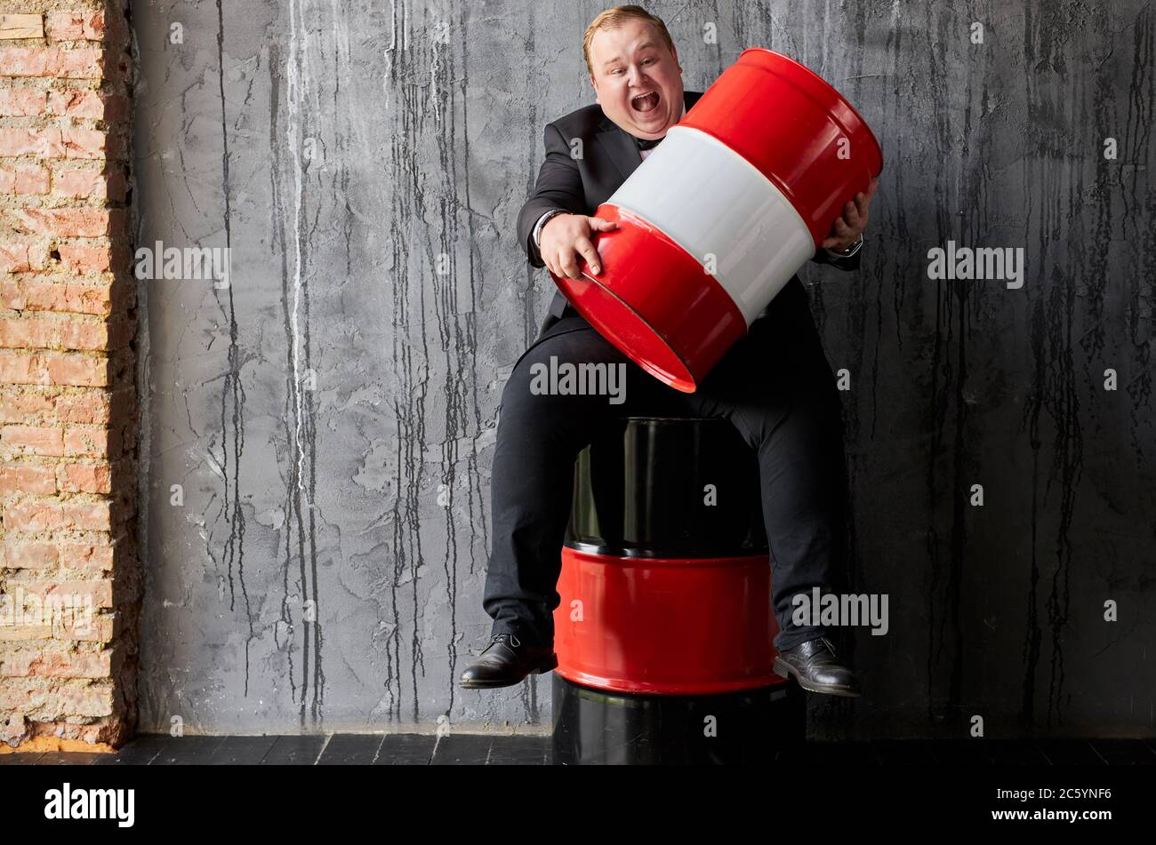 fat caucasian oilman hugs oil barrel, man loves his business connected ...