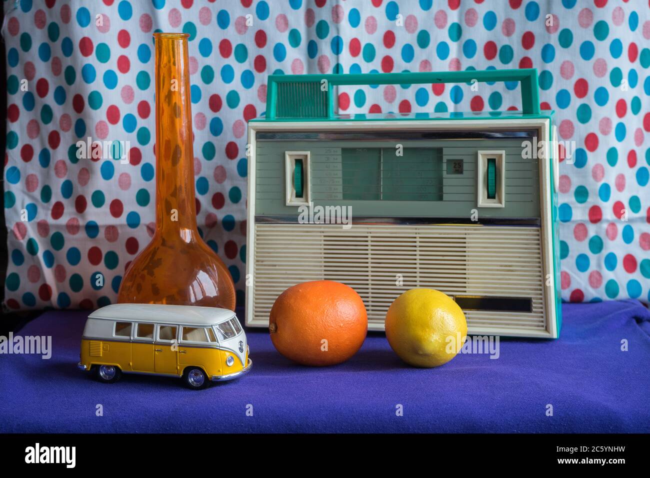 Bright still life with a tape recorder, toy car, vase, orange and lemon ...
