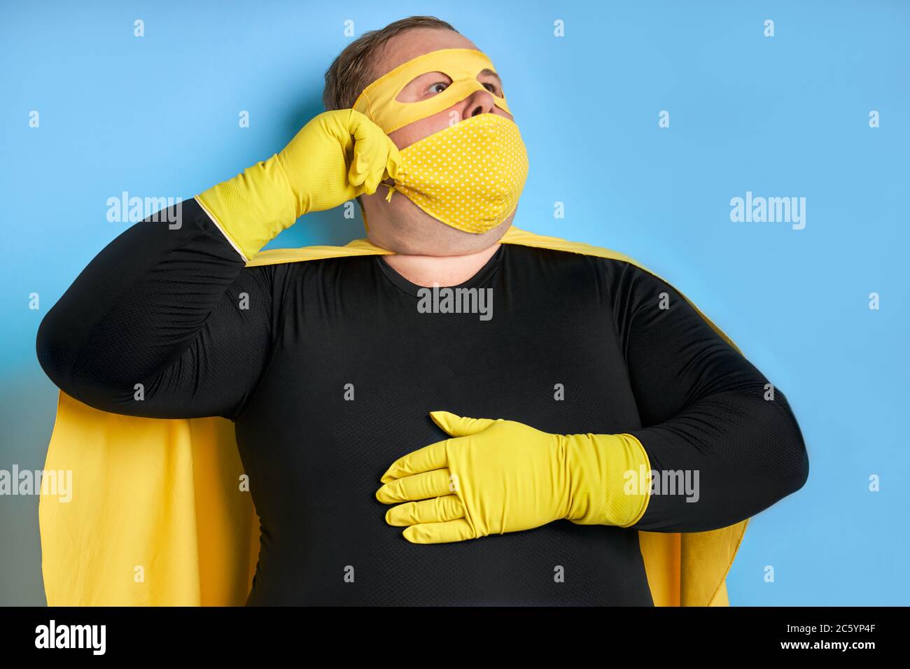 young caucasian fat cleaning man in costume of superhero and in mask ...