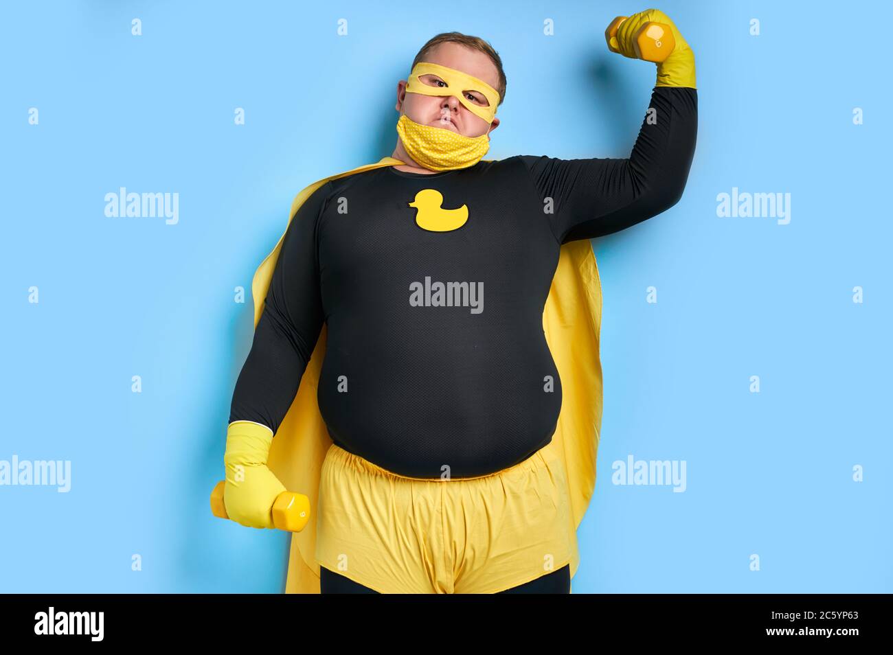 strong fat caucasian man with dumbbells in hands, man wearing yellow ...
