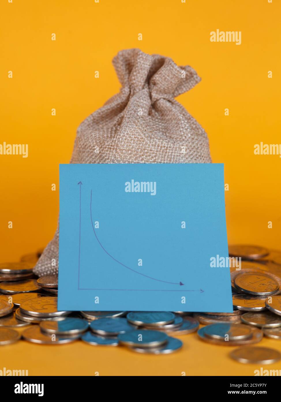 money bag with coins on a yellow background Stock Photo - Alamy