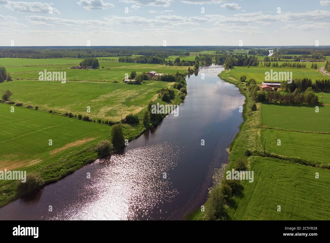 The river runs through the green fields of the rural Finland Stock ...