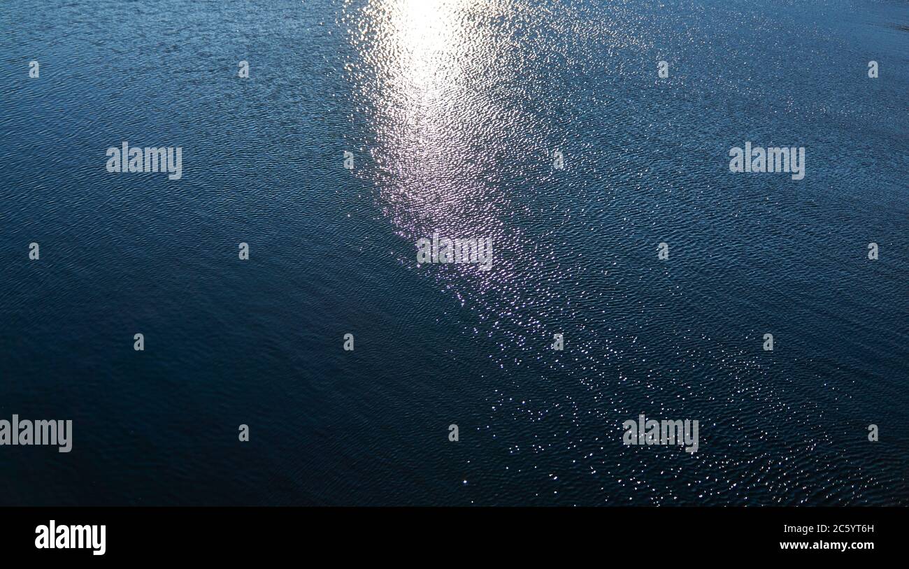 Abstract texture background of bright sun rays reflecting on the waves ...