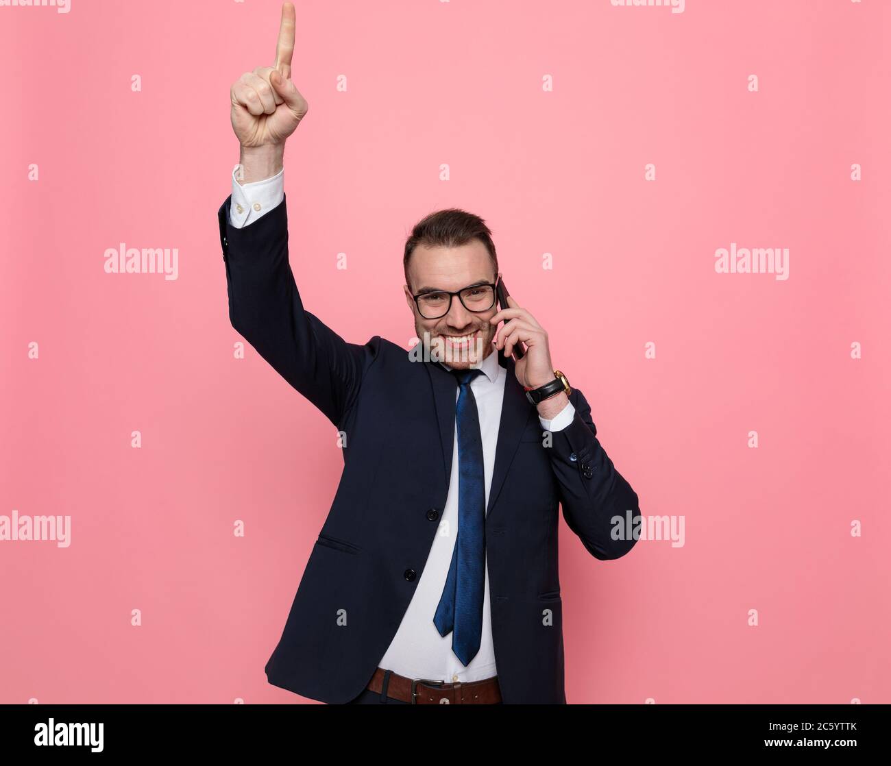 enthusiastic young guy in suit talking on the phone and pointing finger ...