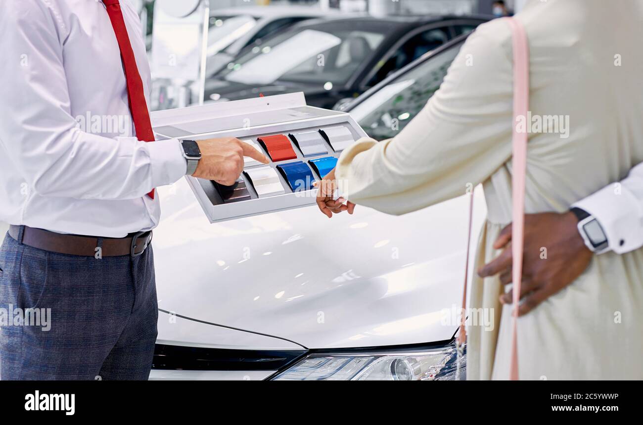 young african clients choose colour of car in dealership, they are ...