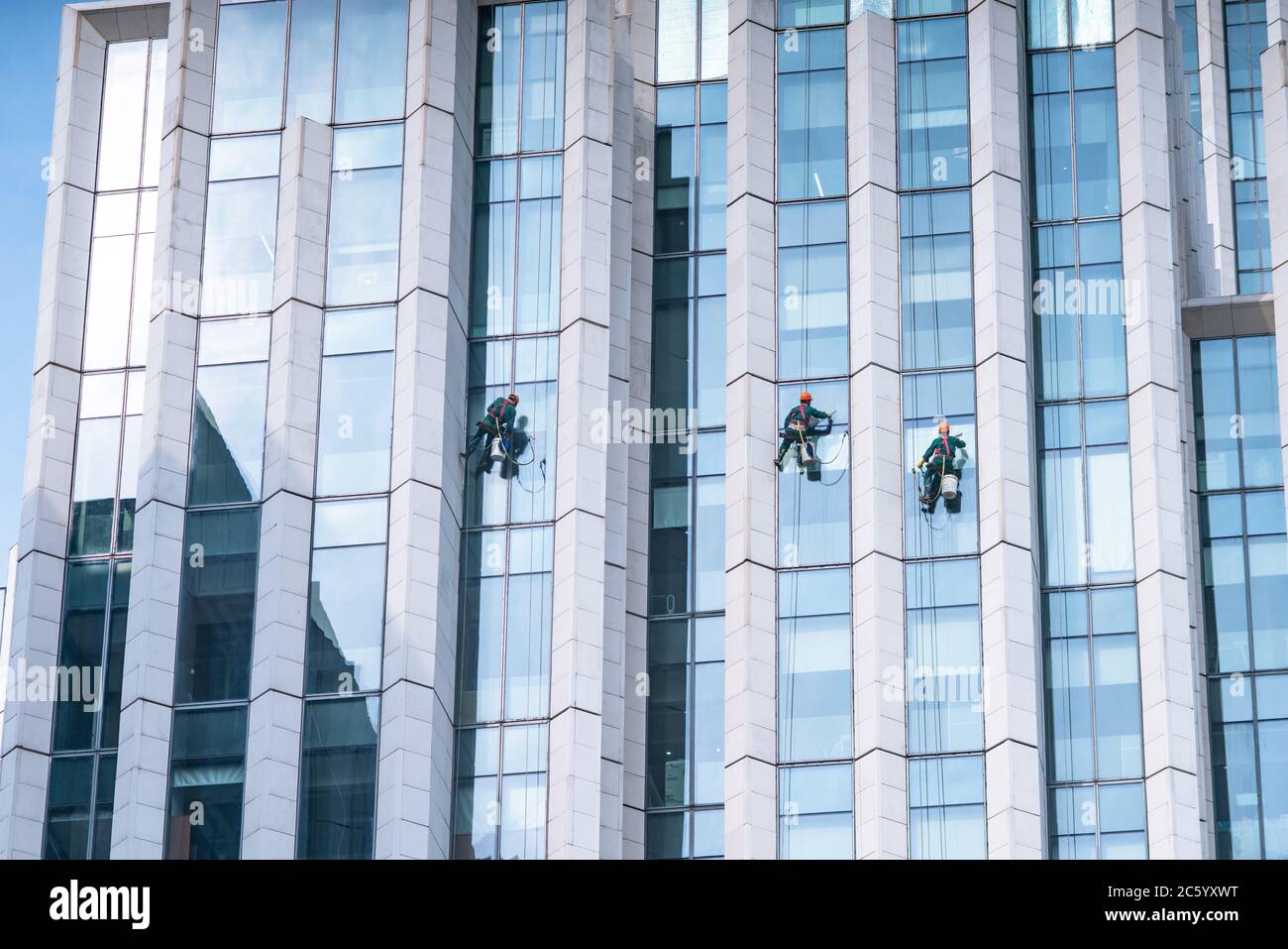Glass wipers working at the facade of a modern skyscraper in Shanghai ...
