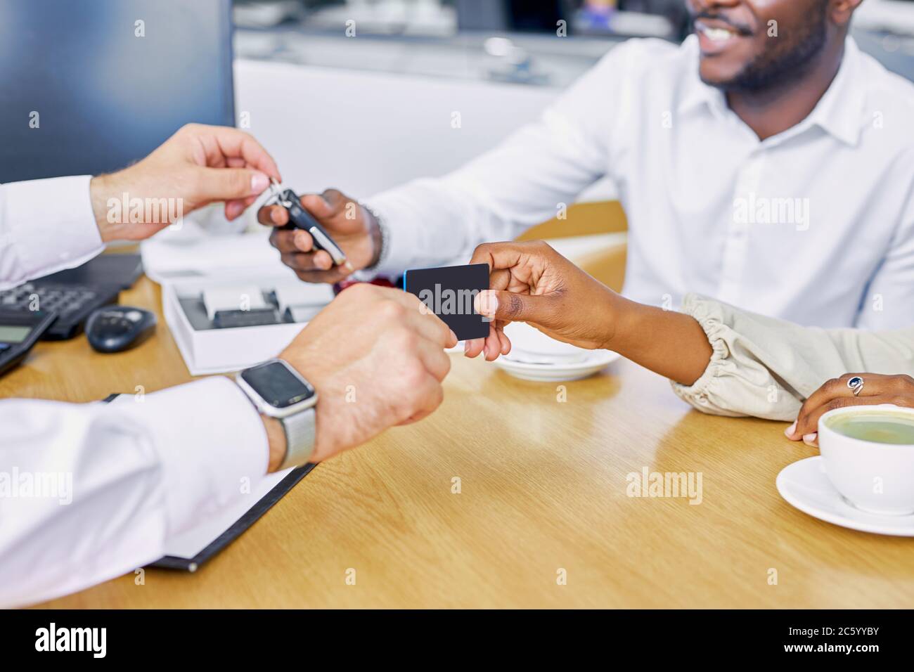 close-up photo of salesman's hand giving business card and keys to ...