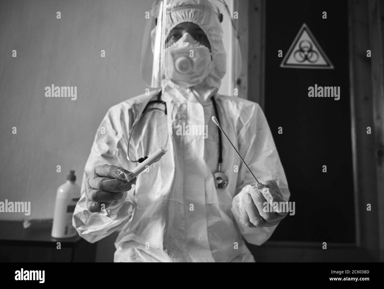 Black and white snapshot of medical worker holding COVID-19 swab ...