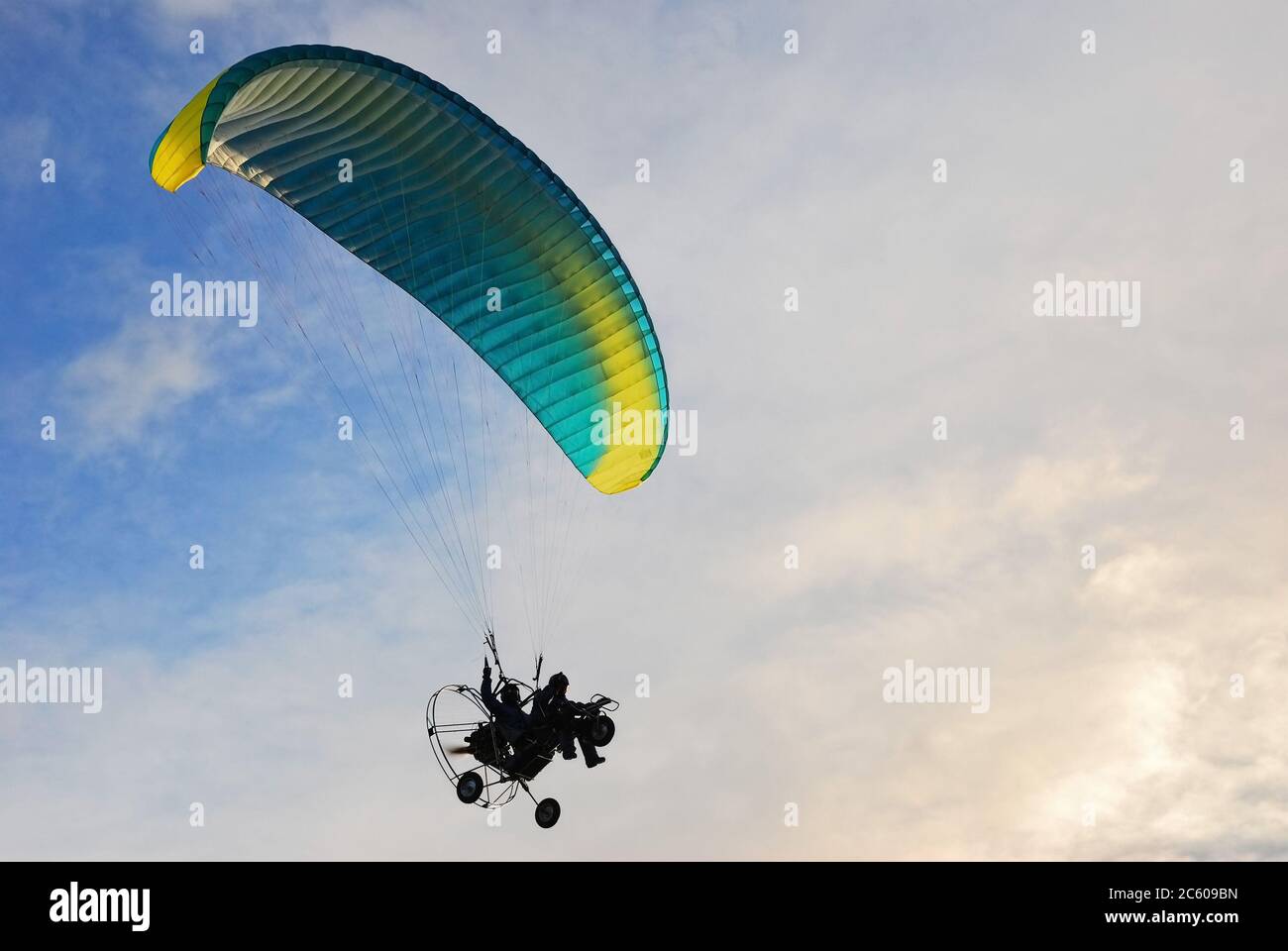 Paragliding in the sky and clouds at sunset time Stock Photo - Alamy