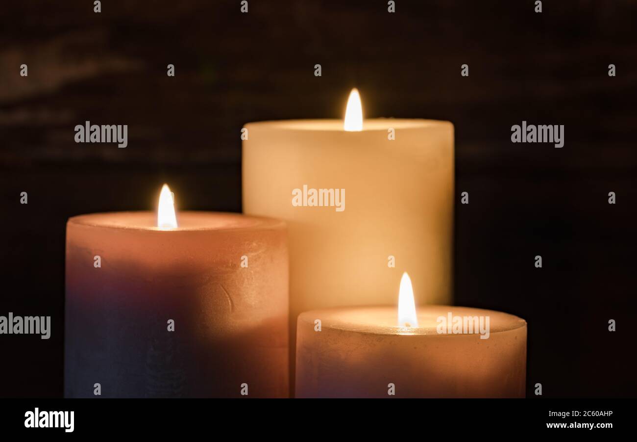 Three burning candle flames at night Stock Photo - Alamy