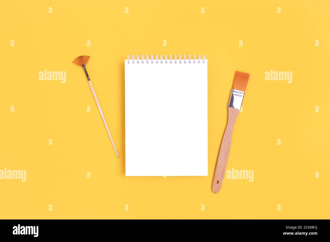 Notepad mockup with paint brushes on a bright yellow background ...