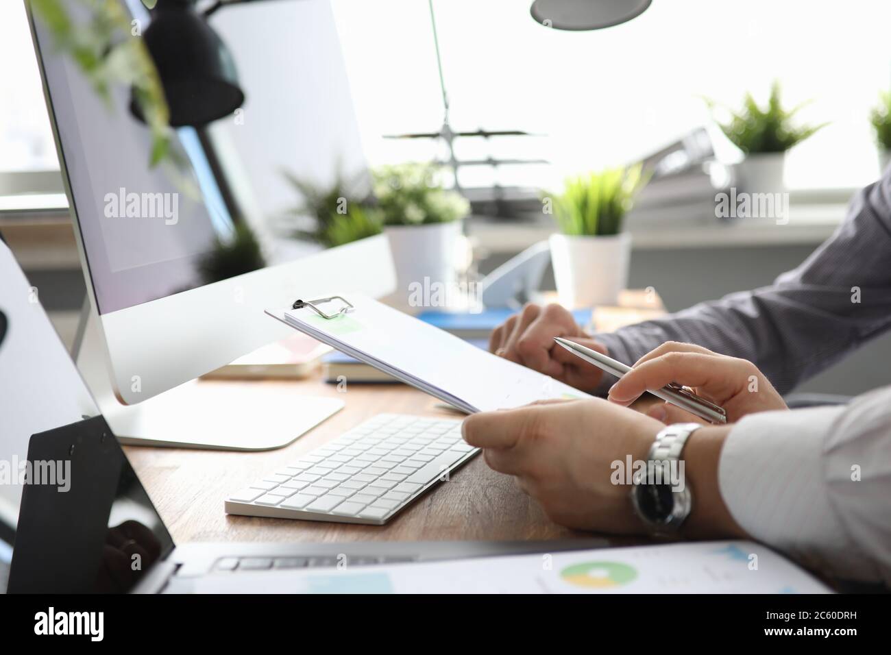 Two employees sitting at desk with a computer Stock Photo - Alamy