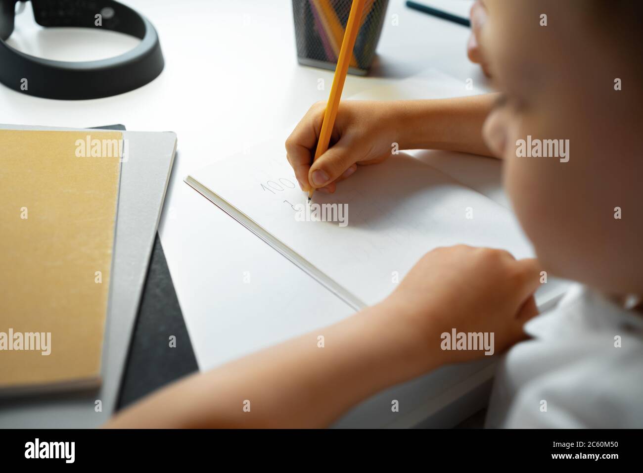 Little boy writing something in his notebook Stock Photo - Alamy