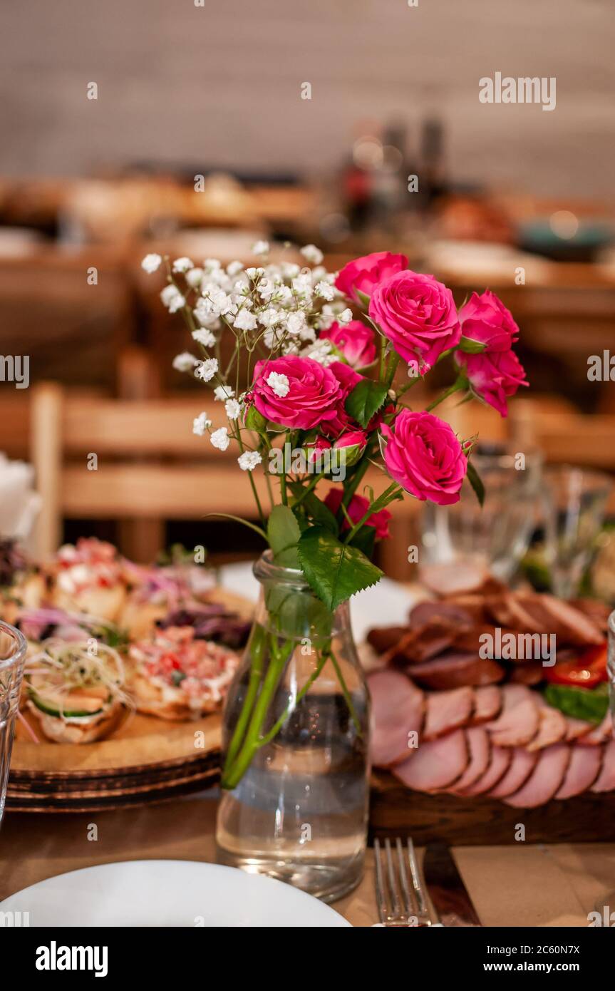 Flowers in a transparent vase at a buffet Stock Photo - Alamy