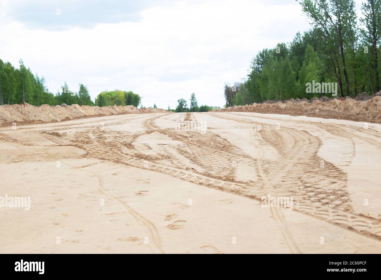 The construction of a wide road and sidewalk. Marking in the sand for a ...
