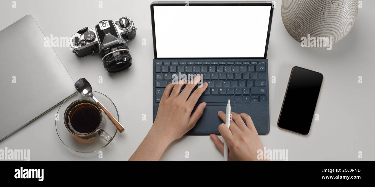 Overhead shot of female working on simple workspace with mock-up ...