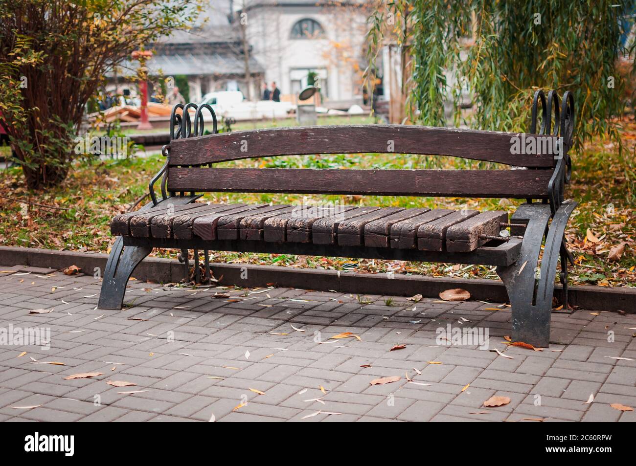 Wooden bench with a metal railing in the park Stock Photo - Alamy