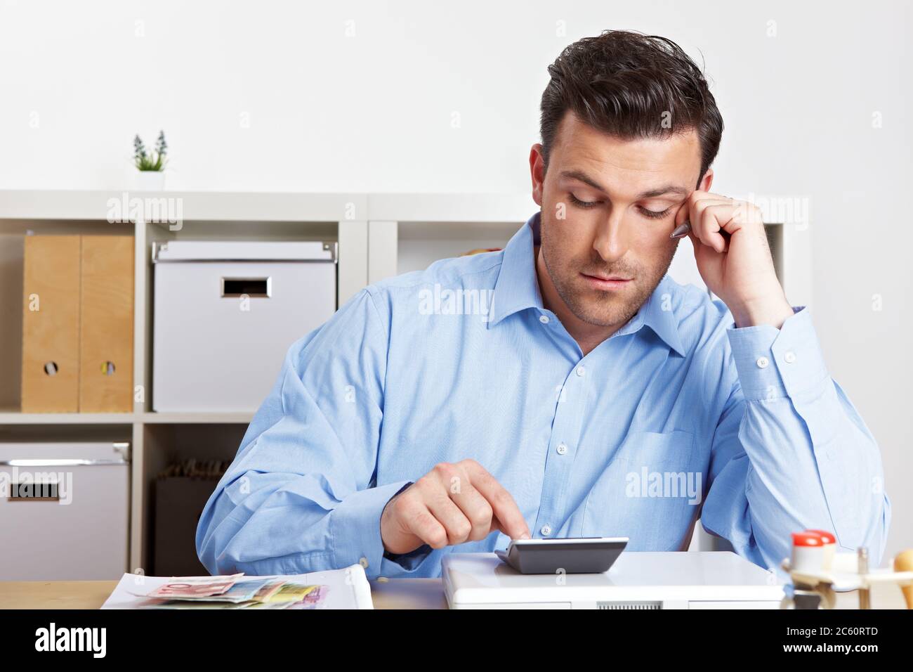 Manager in the office at the desk calculates with calculator Stock ...