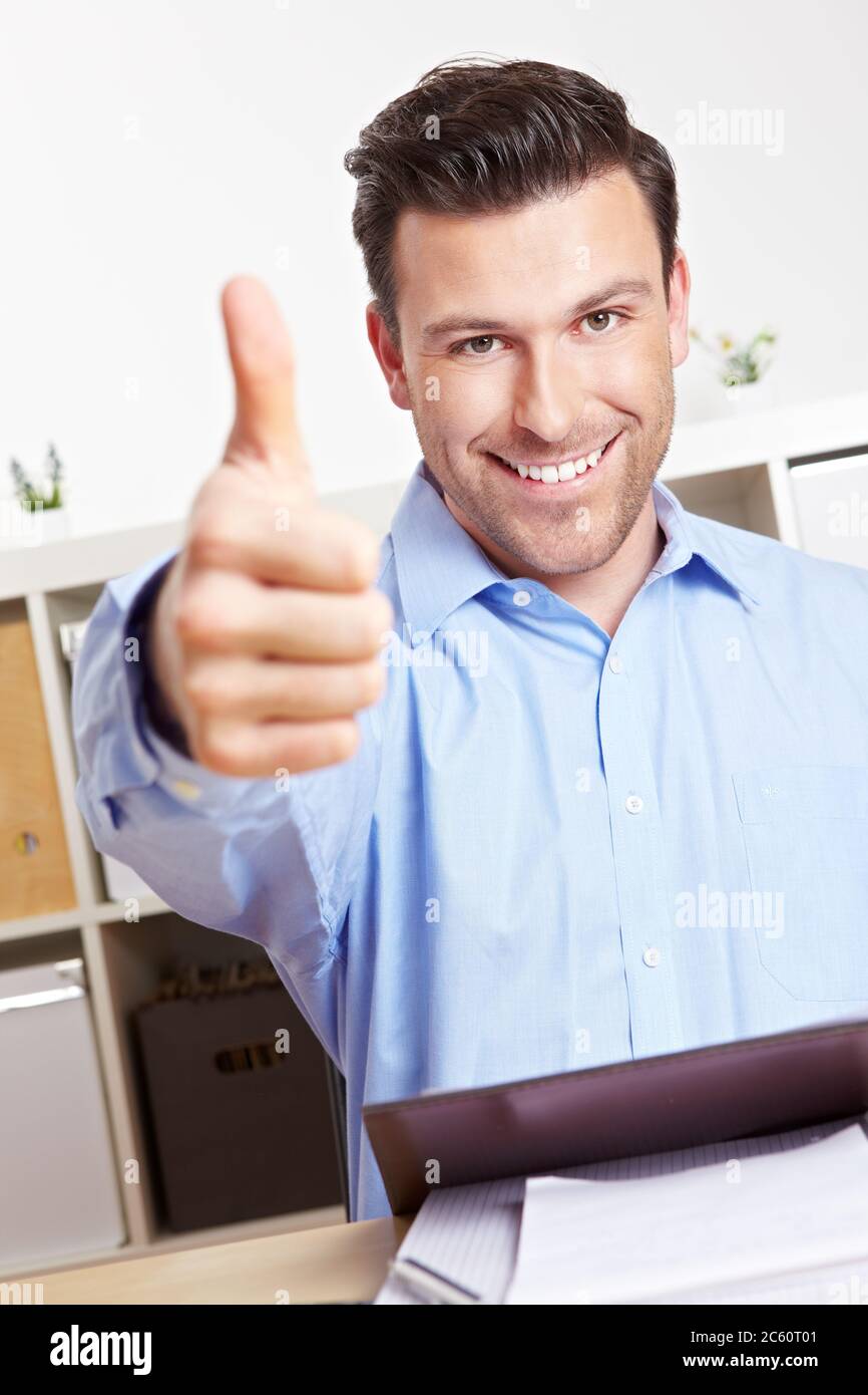 Happy manager holds thumbs up in the office Stock Photo - Alamy