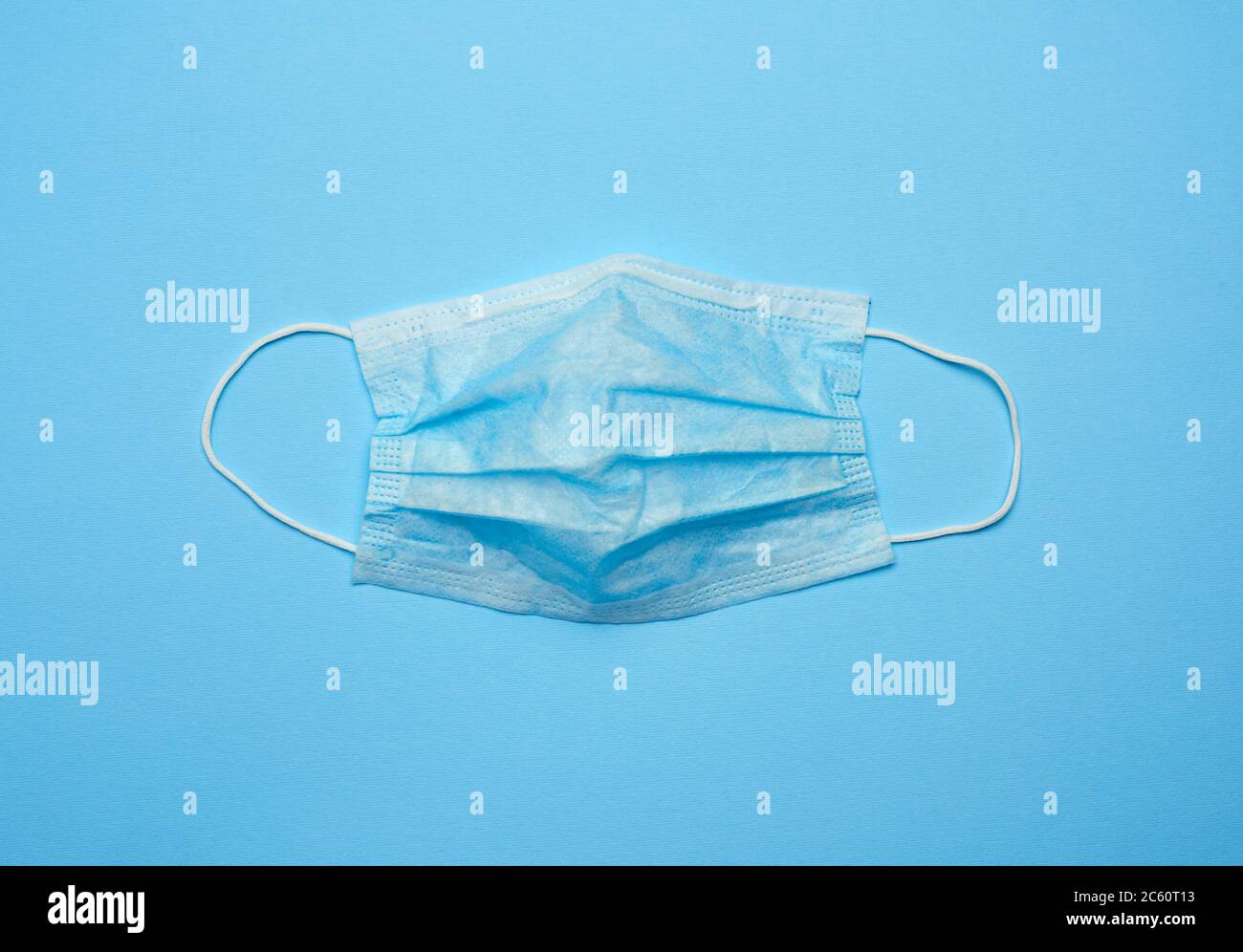 blue disposable medical mask on a blue background, personal protective ...