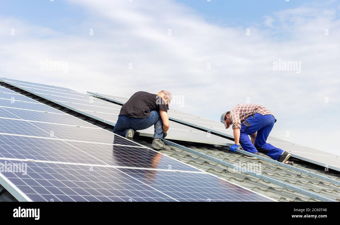 Electrical engineers mans are working installing solar panels on solar ...