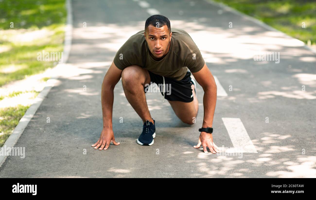 Serious black sportsman ready to run marathon race at park Stock Photo ...