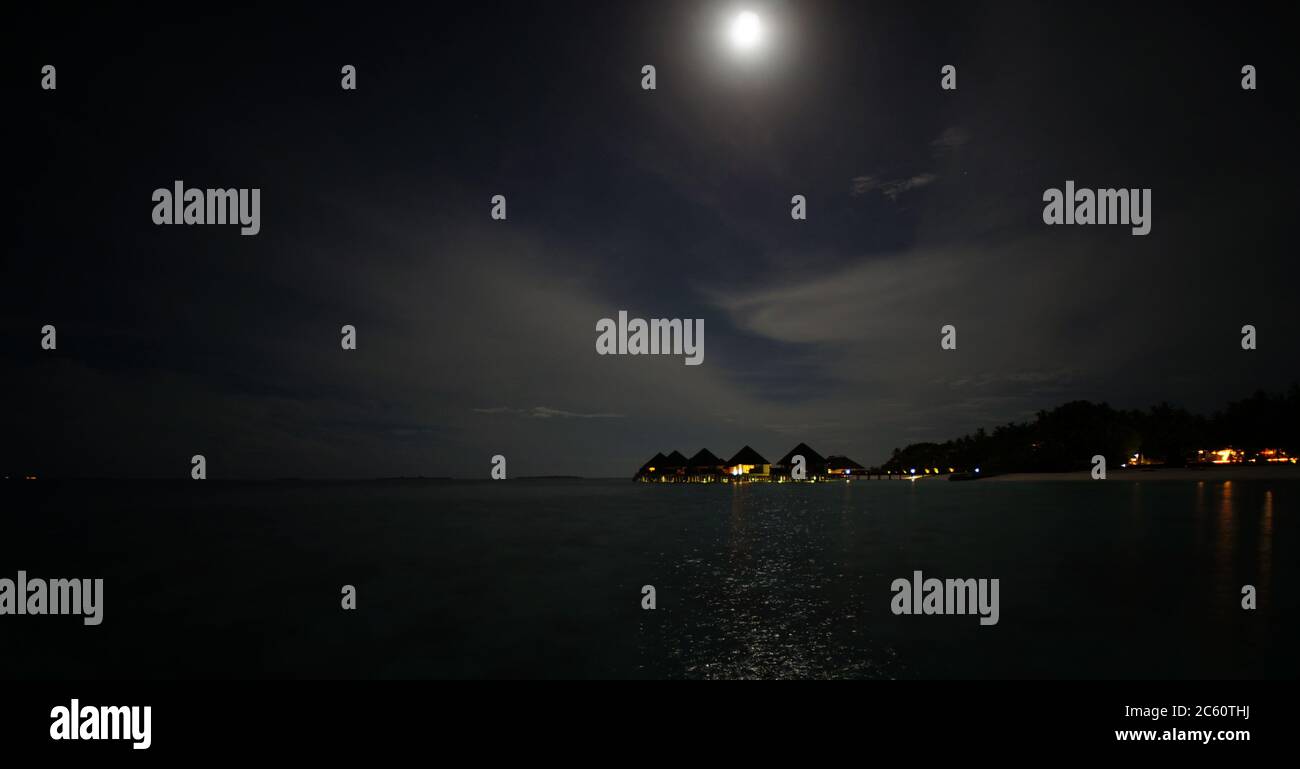 Maldivian Luxury Resort at night with the moon shining Stock Photo - Alamy