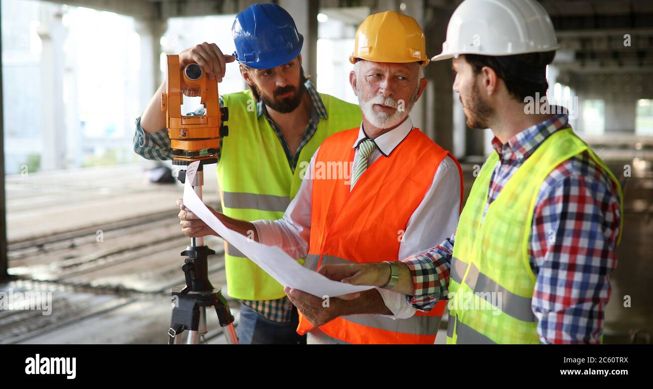 Team of construction engineers, architects working on building site ...