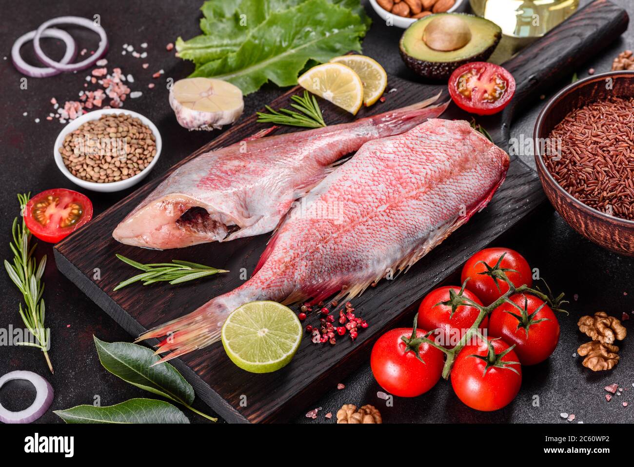 Raw fillet of red sea perch prepared for baking with spices and herbs ...