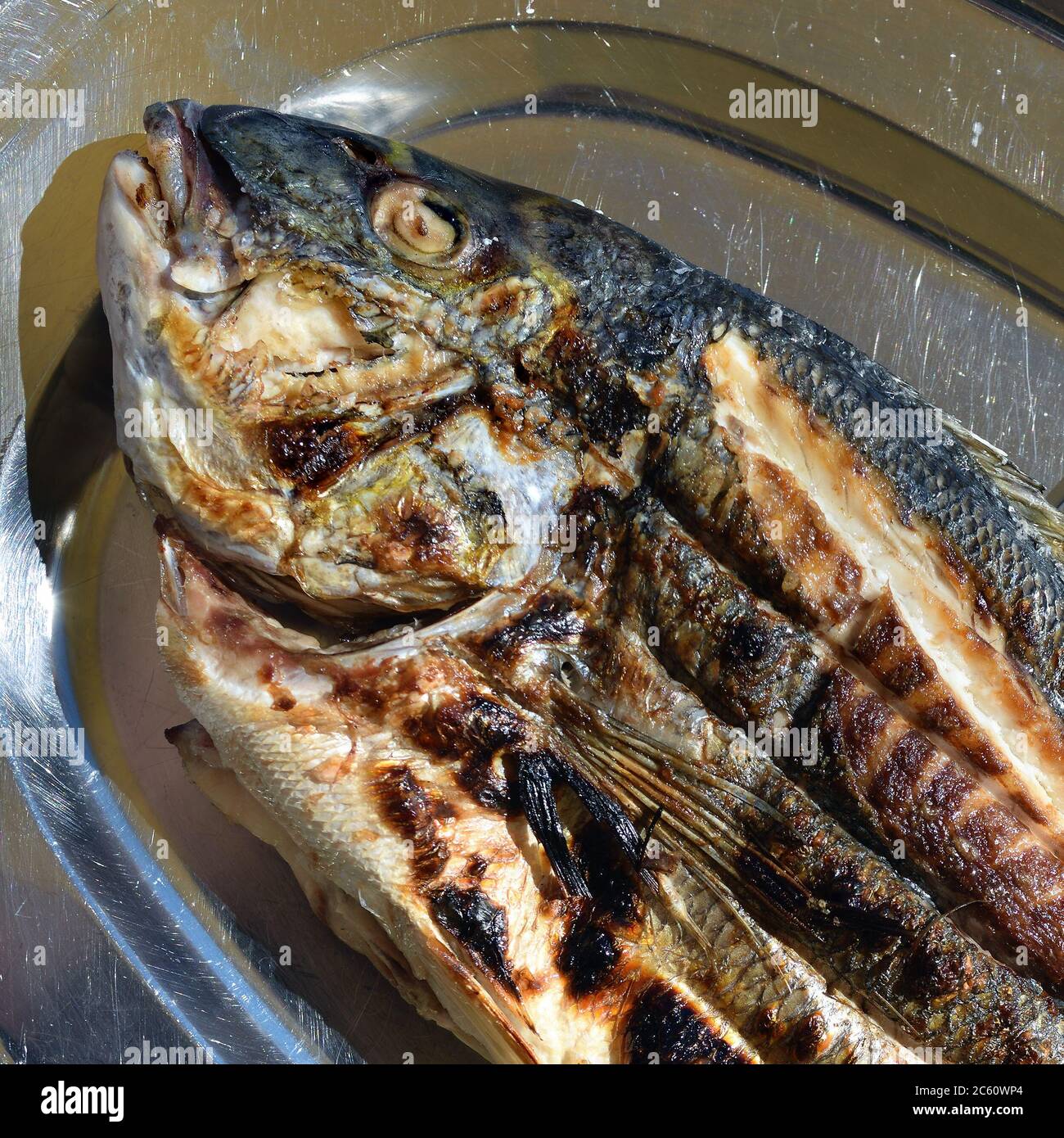 Grilled sea bass fish on the metal plate, Mediterranean cuisine, Attica ...
