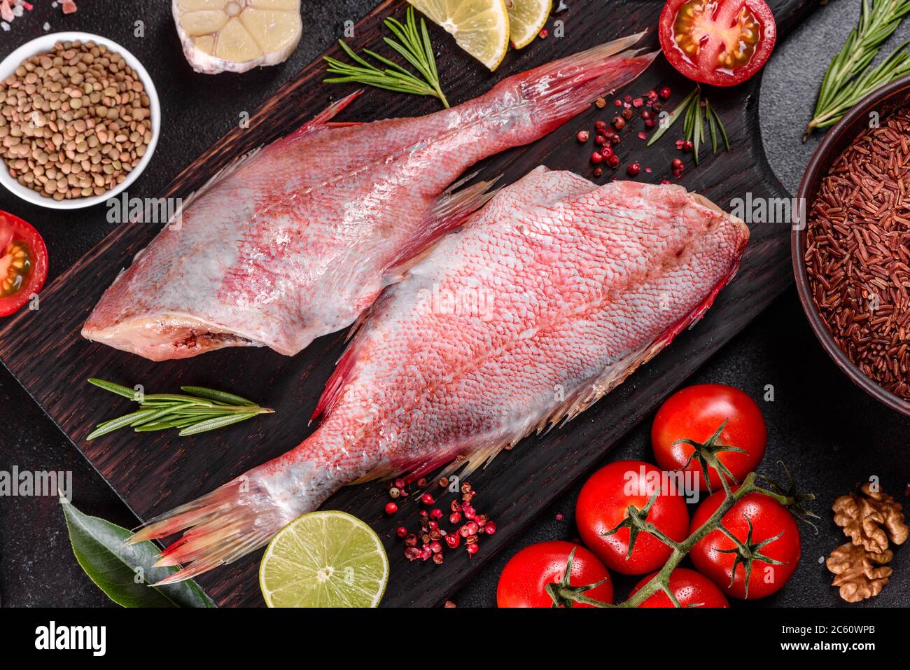 Raw fillet of red sea perch prepared for baking with spices and herbs ...