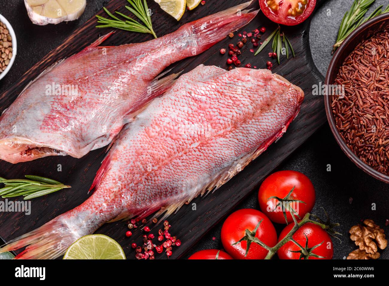 Raw fillet of red sea perch prepared for baking with spices and herbs ...