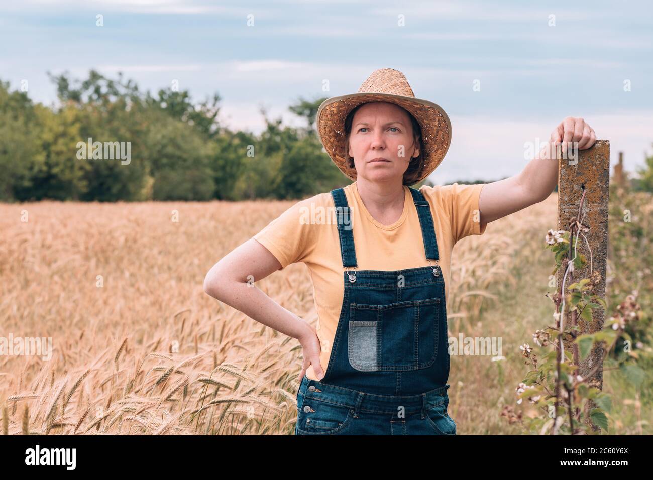 Female farmer posing in ripe barley field just before the harvest ...
