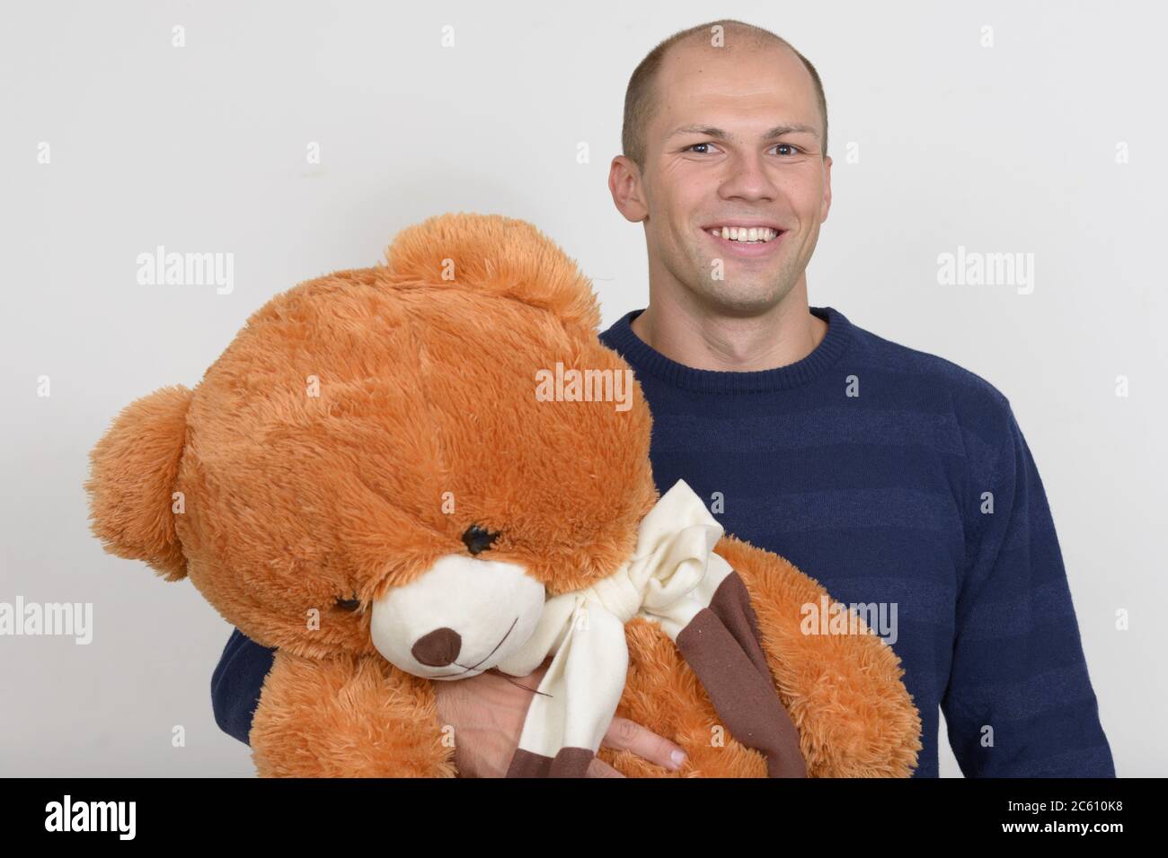 Portrait of happy young handsome bald man holding big teddy bear Stock ...